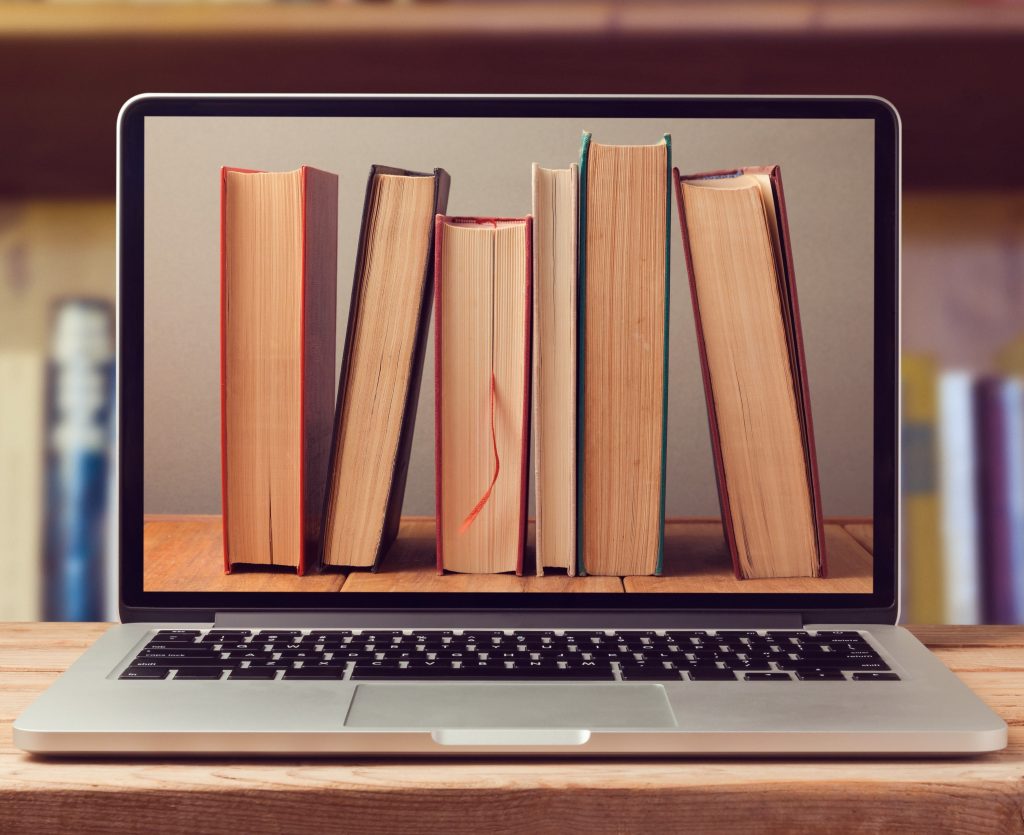E-book library concept with laptop computer and books – PHDL Me This